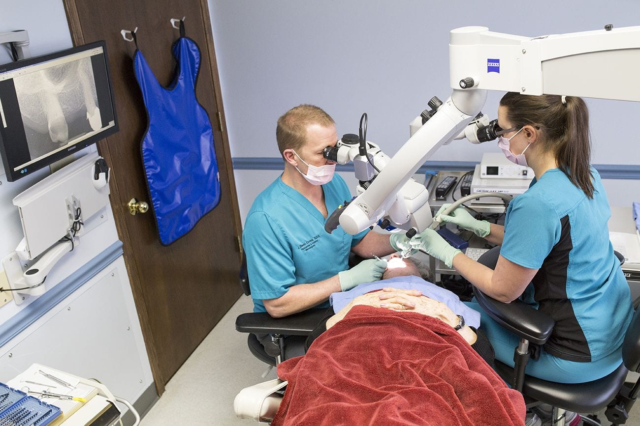 Aerial View of Dr. Cross and Staff Member Looking Through Microscope ...